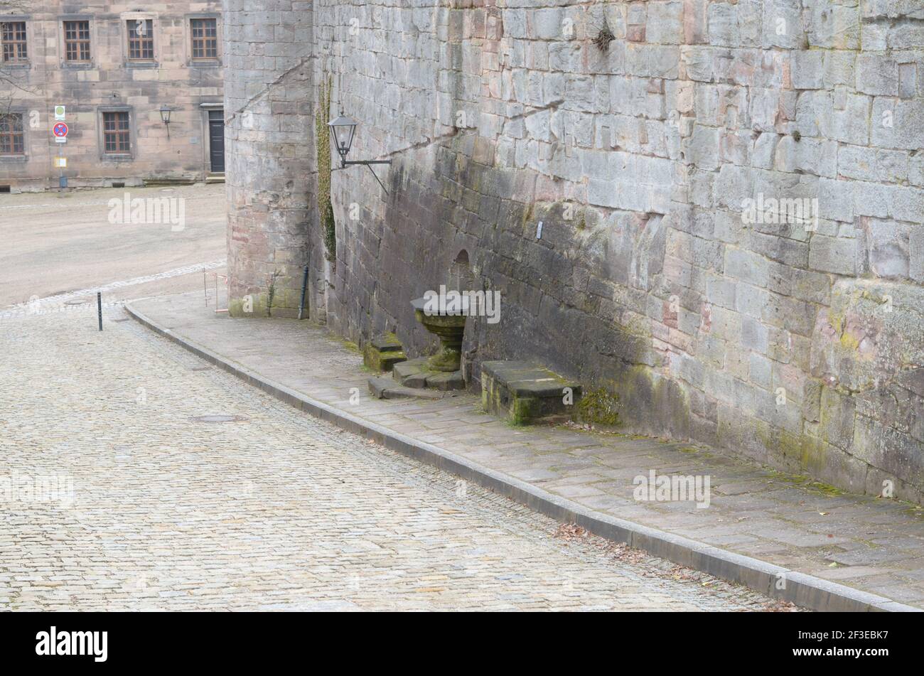 The mossy walls of old stone buildings with stone bench and table on ...