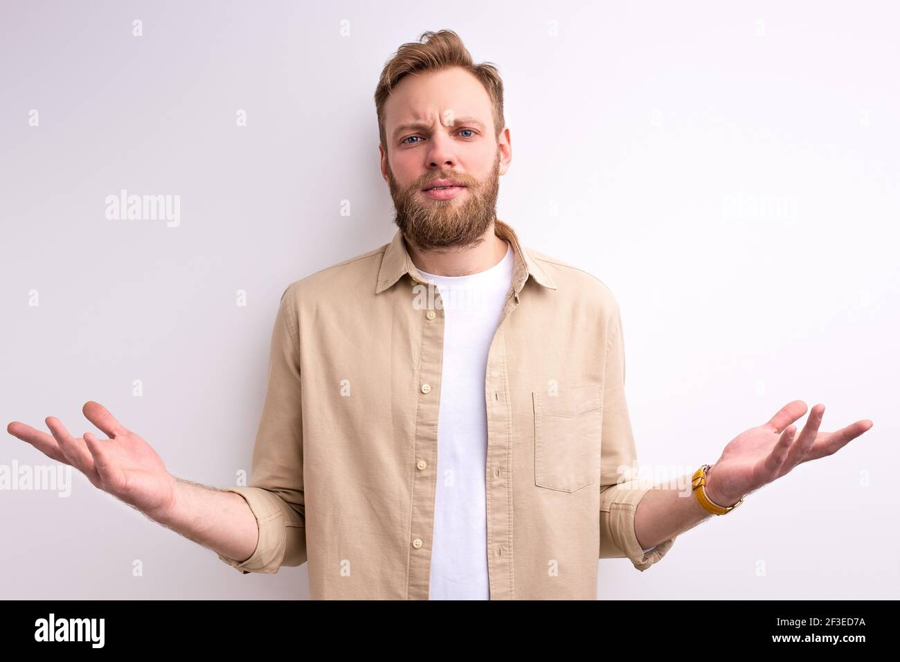 Irritated annoyed man with beard has problems, gesticulating with hands ...