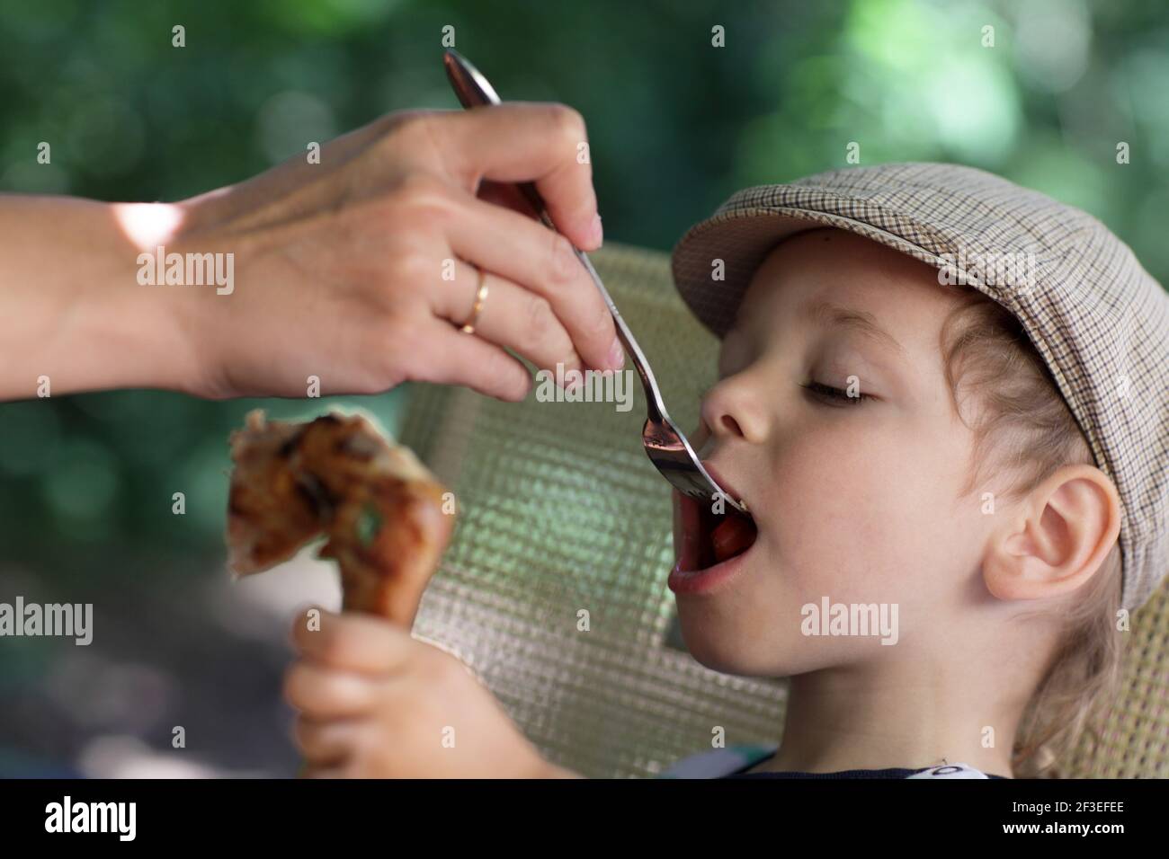 Boy eating chicken in the outdoor cafe Stock Photo - Alamy