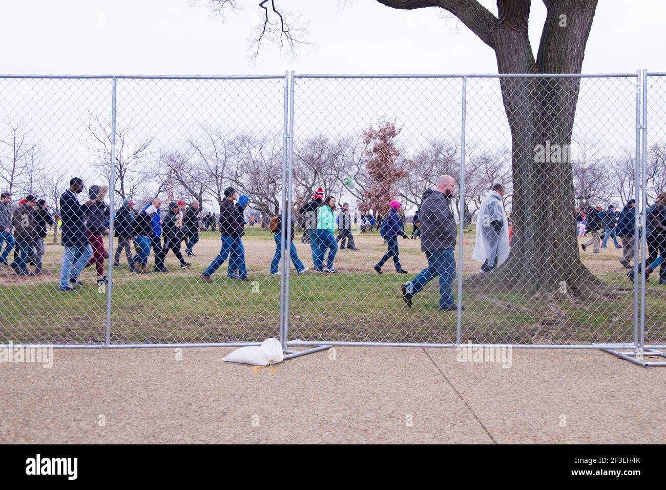 People walking inside secure Mall area behind chain link fence. At ...