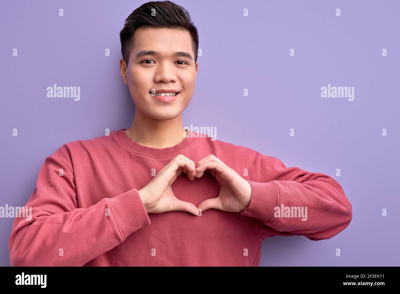 chinese guy expressing love at camera, making shape of heart from hands ...