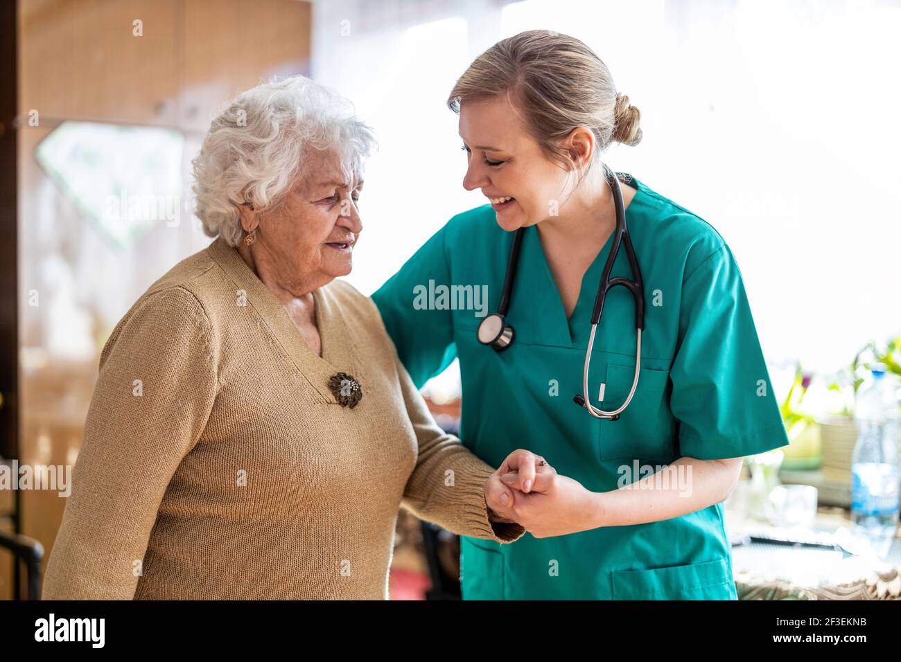 Friendly nurse supporting an elderly lady Stock Photo - Alamy