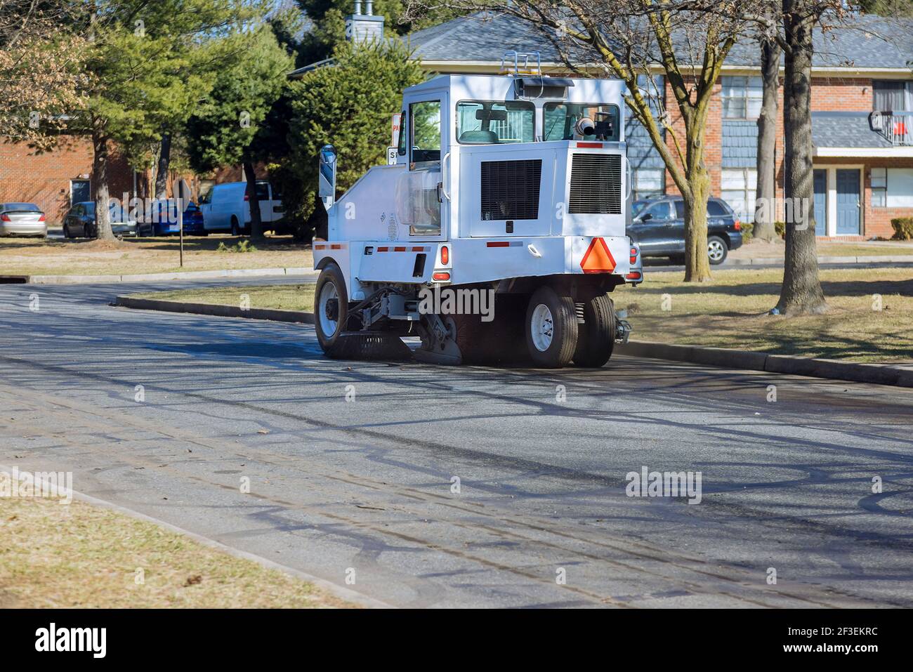 Cleaning sweeper machines washes the asphalt road with water spray of ...