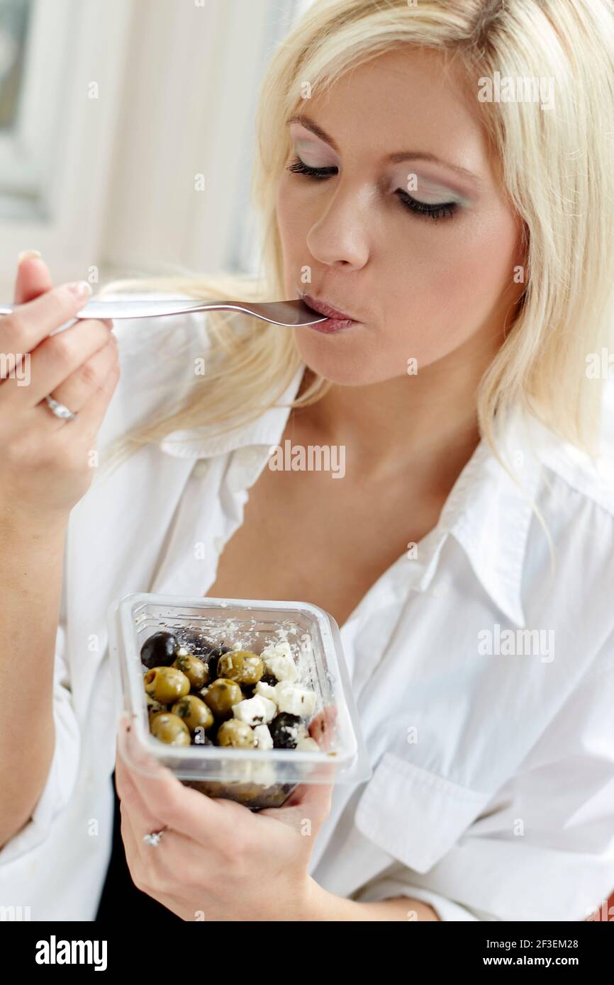 Woman eating cheese and olives Stock Photo - Alamy