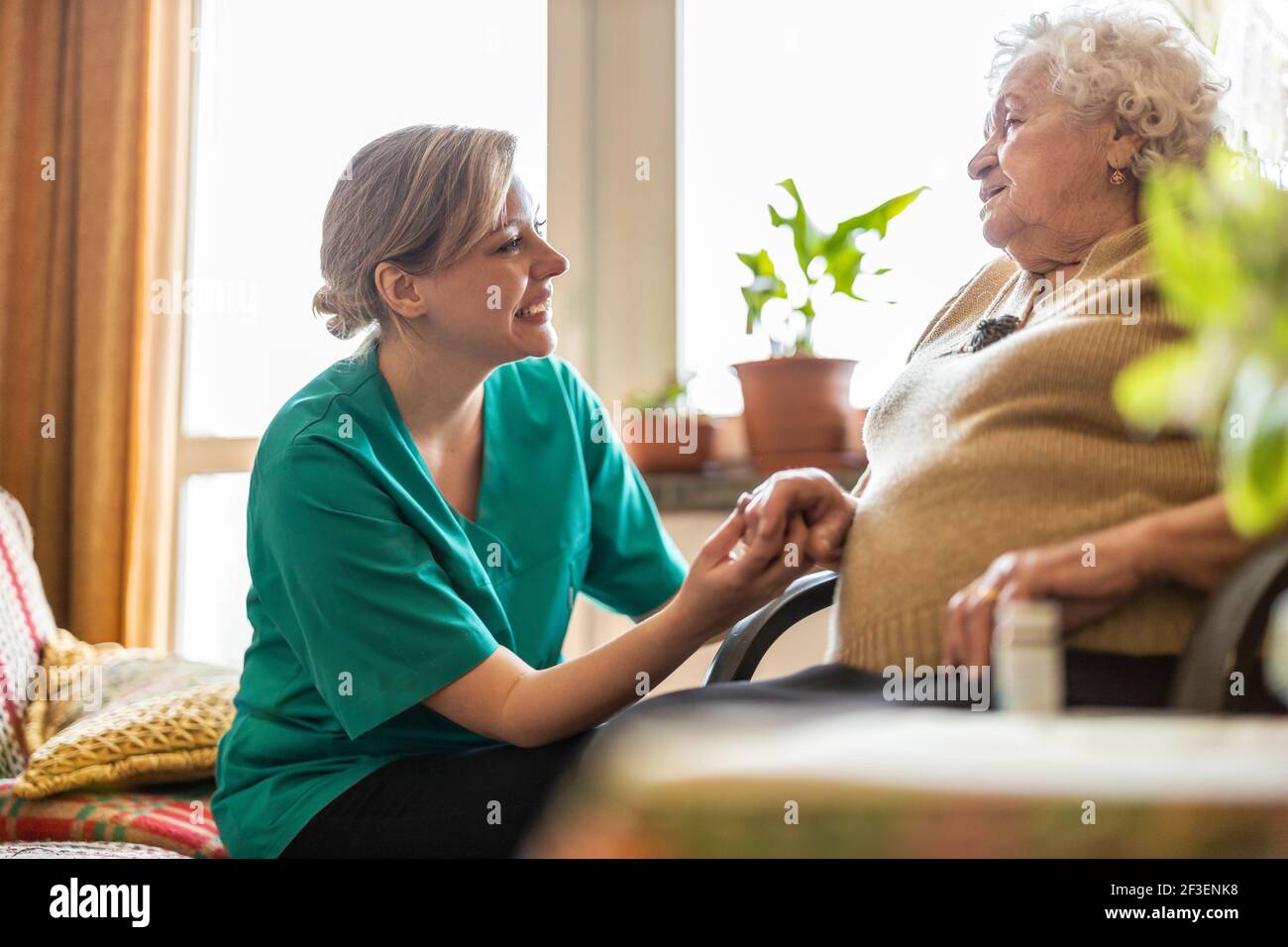 Friendly nurse supporting an elderly lady Stock Photo - Alamy