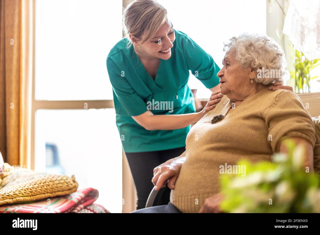 Friendly nurse supporting an elderly lady Stock Photo - Alamy