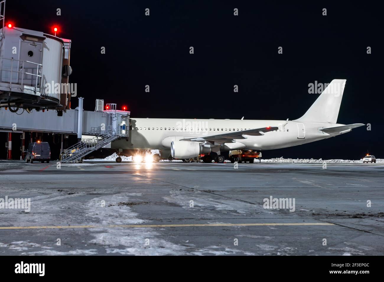 Modern passenger jet plane at the air bridge on night airport apron ...