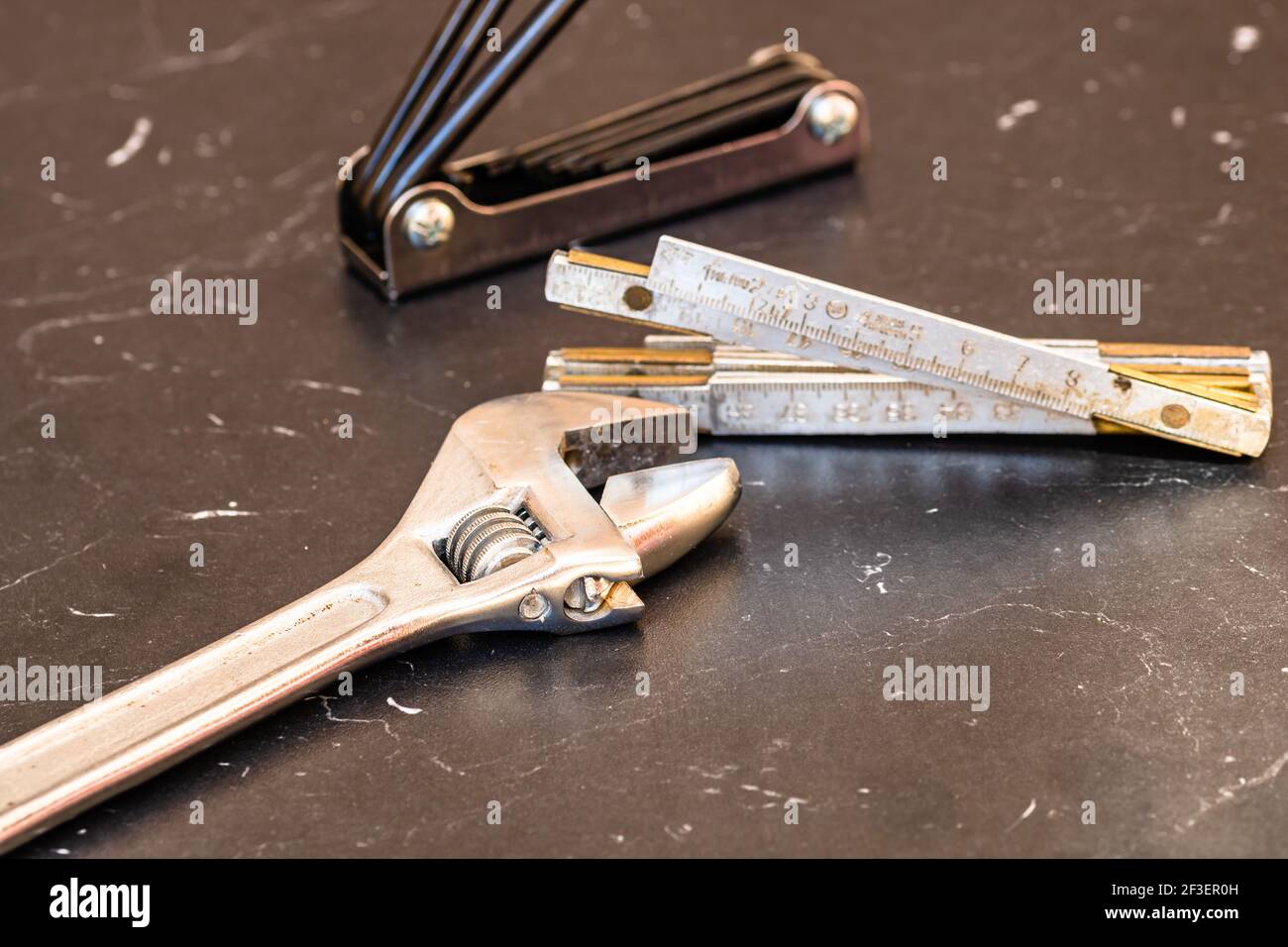 A low-angle shot of adjustable spanner, ruler, and instruments for ...