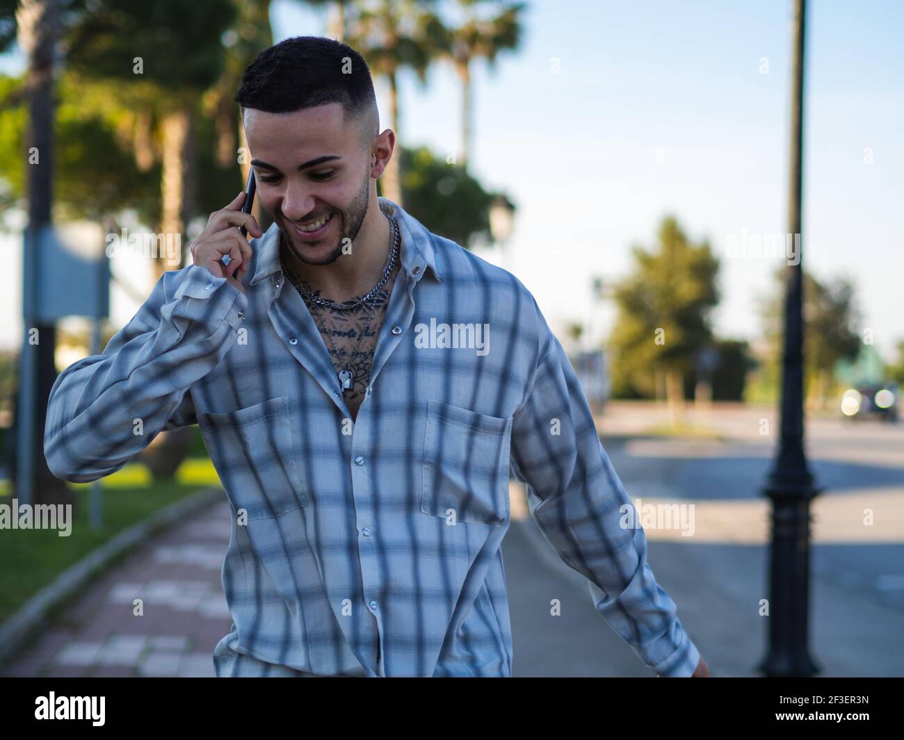 A Spanish stylish man with tattoos talking on the phone Stock Photo - Alamy