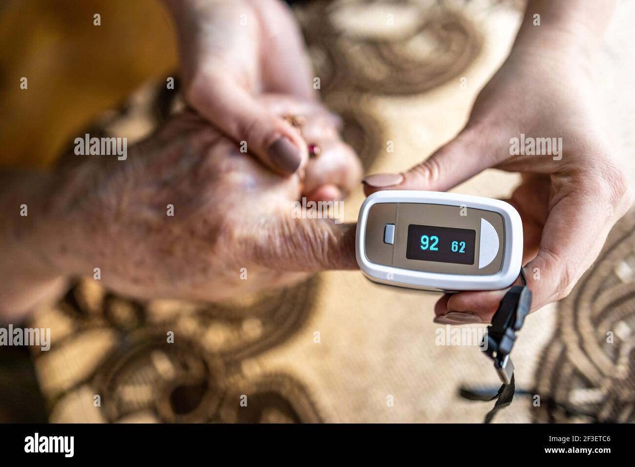 Oximeter for checking oxygen saturation in blood on senior woman’s hand ...