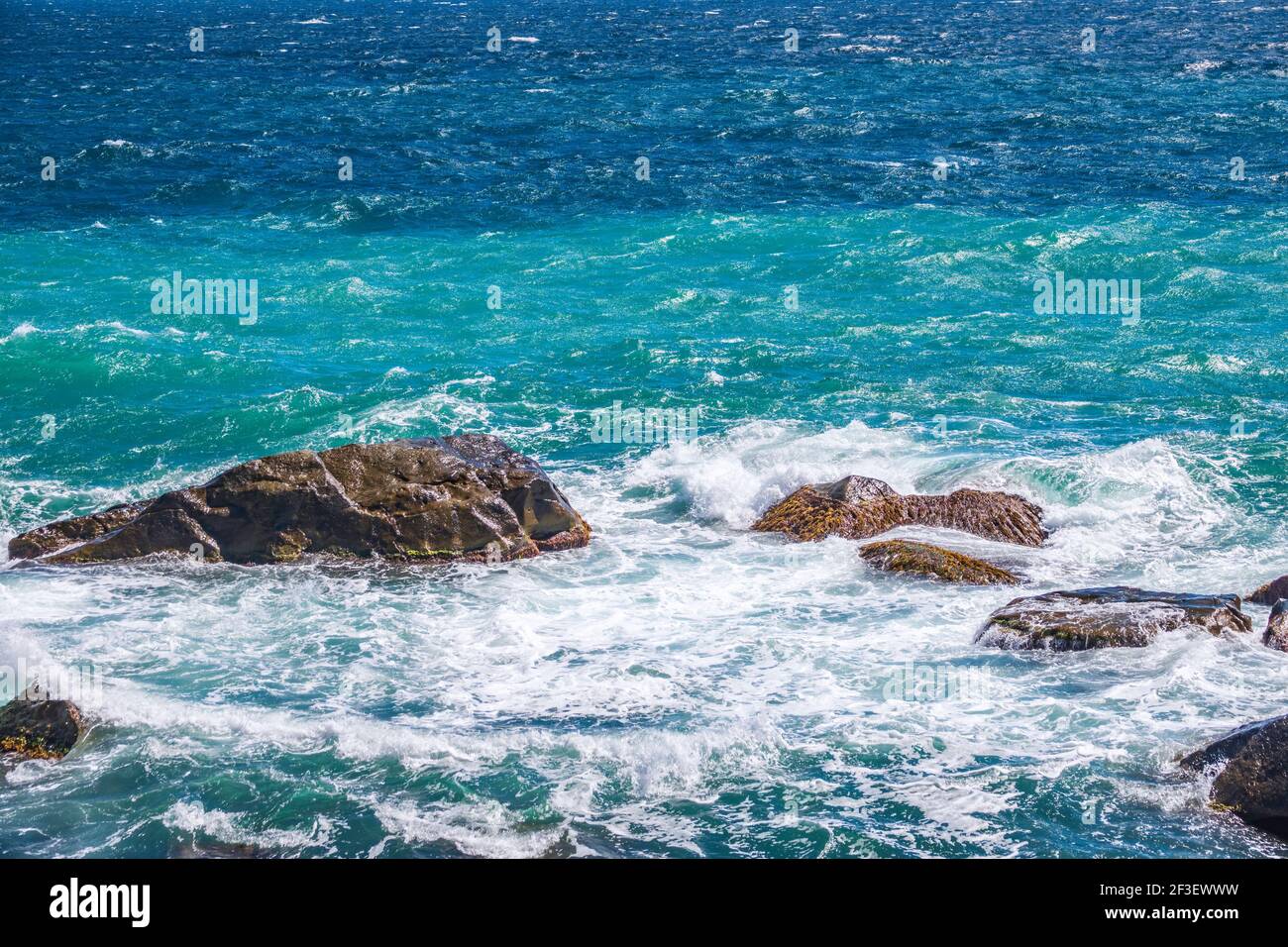 Sea water beats against rocks. Sea waves of dark water beat against the ...