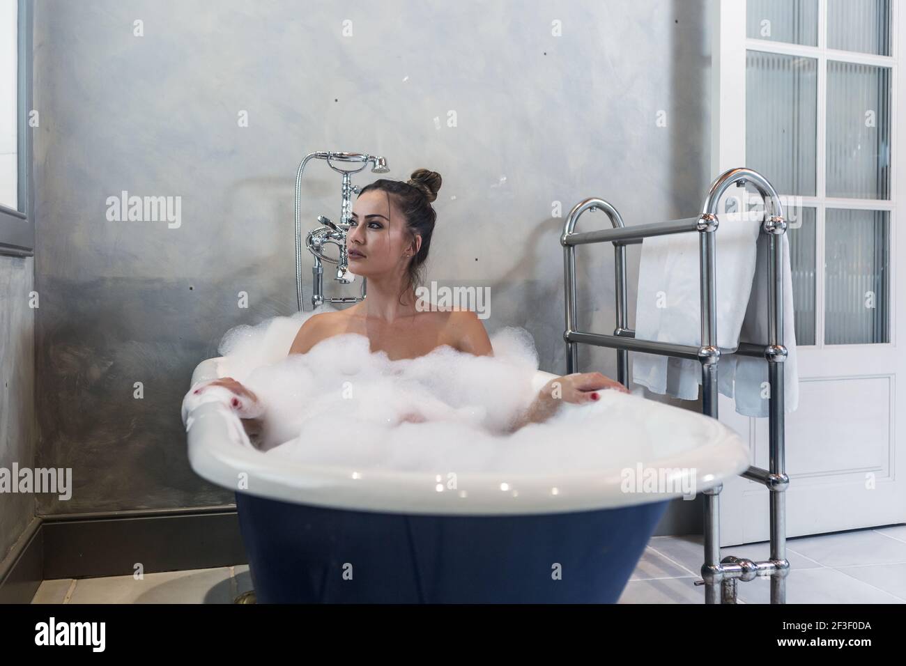 Alluring Woman Taking Taking Foamy Bath In Luxury Bathroom At Home And Looking Dreamily Away