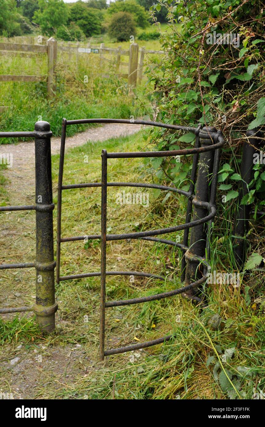 Unusual design old cast iron swinging stile, kissing gate on a footpath ...