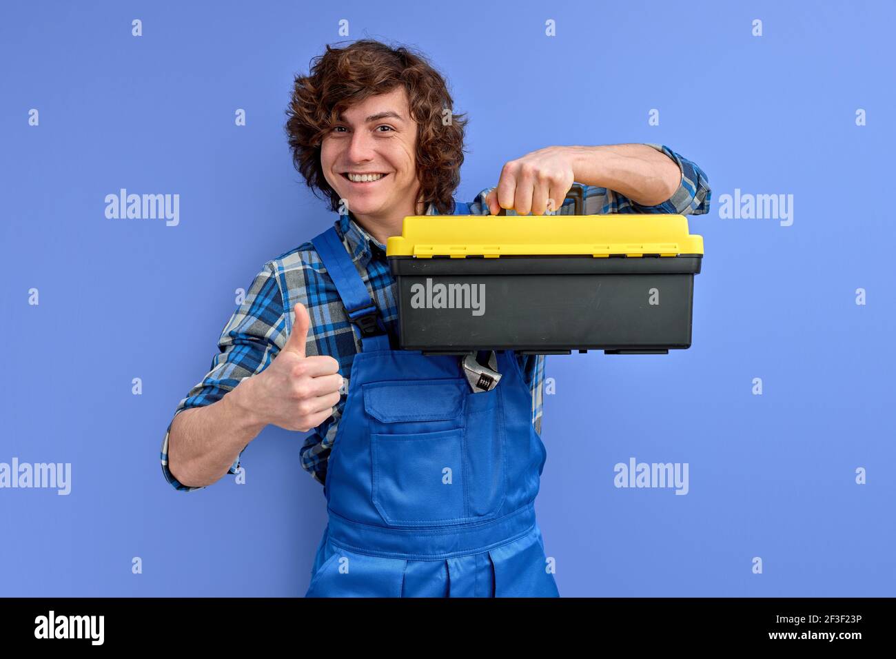 qualified workman in overalls carrying instruments isolated over purple ...