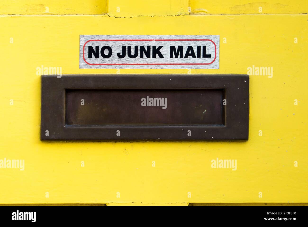 House letterbox with 'No junk mail' sign at a yellow vintage door Stock ...
