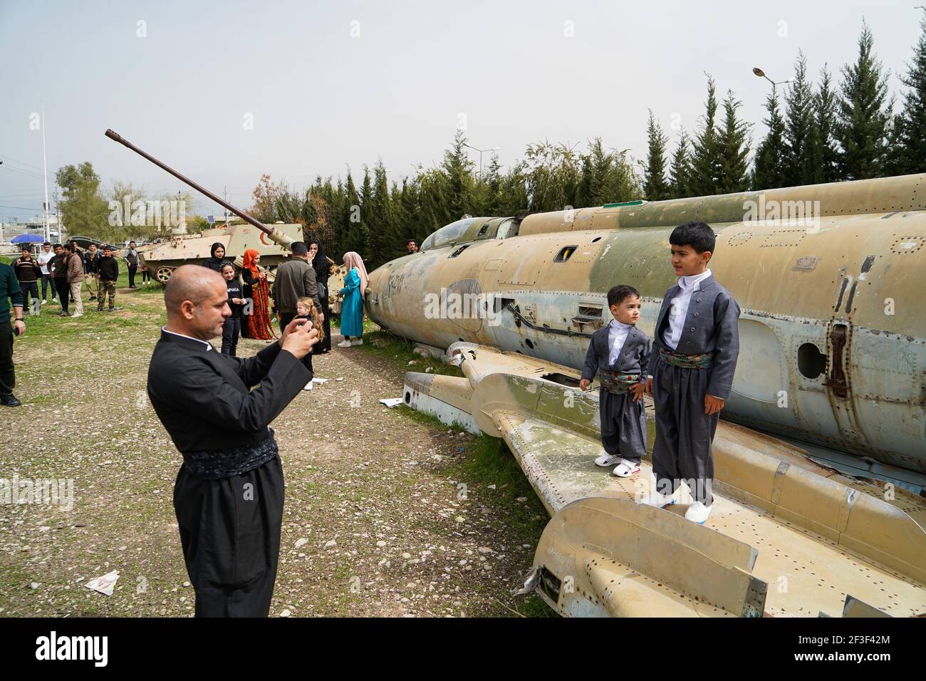 Halabja, Iraq. 16th Mar, 2021. A man takes pictures of children posing ...