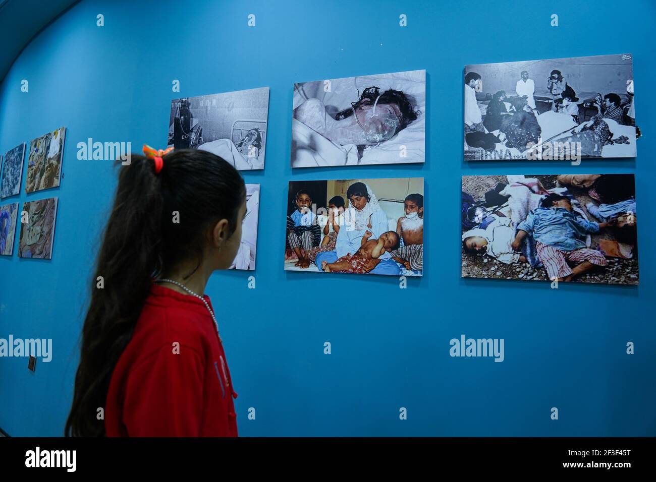 A girl views photos of victims of the Halabja chemical attack during ...