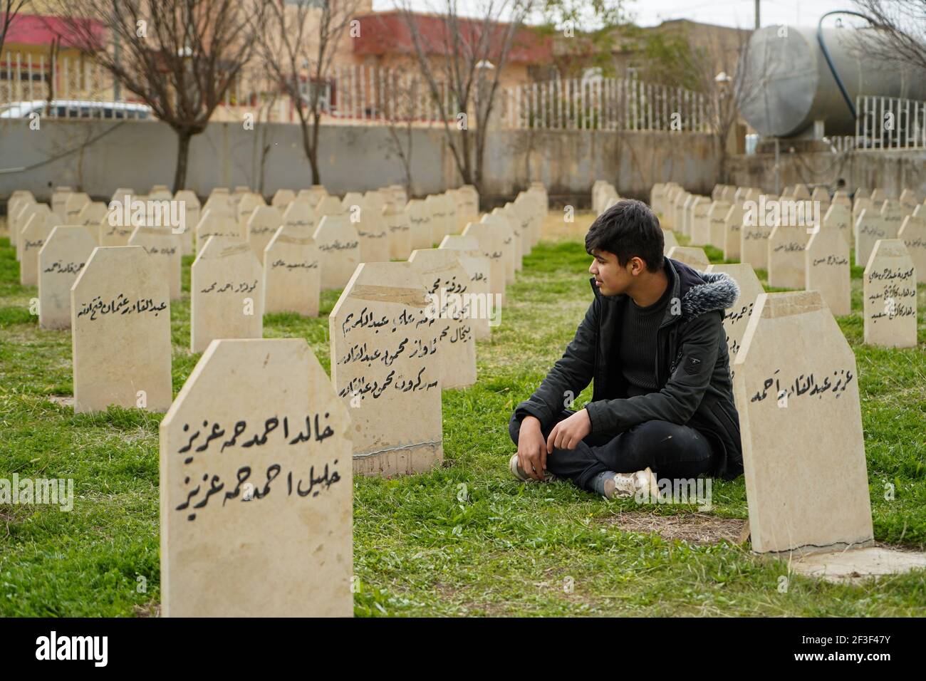 A man sits in the graveyard of the victims of the Halabja chemical ...