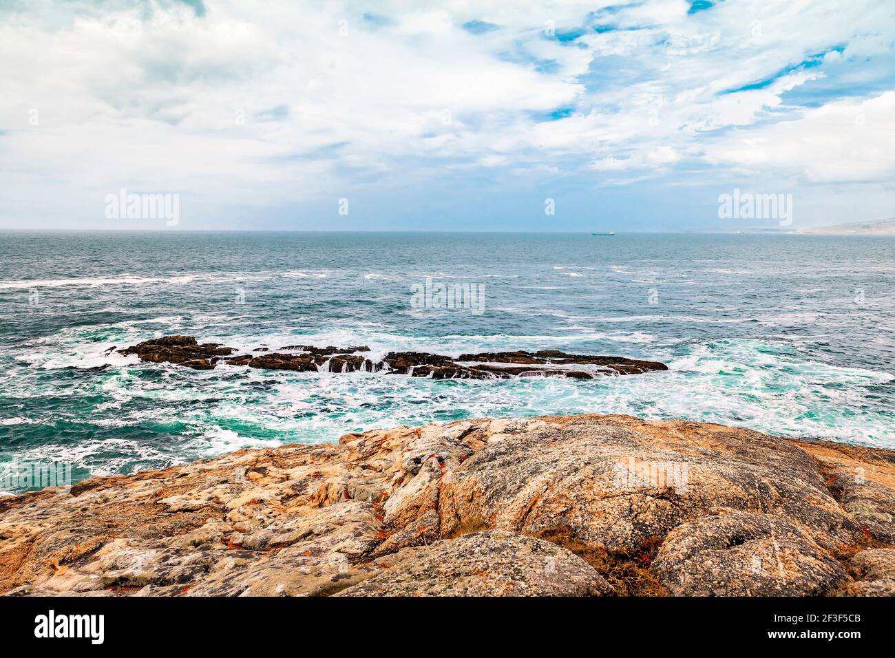 rocky shore with blue and green sea rocks eroded by water Stock Photo ...