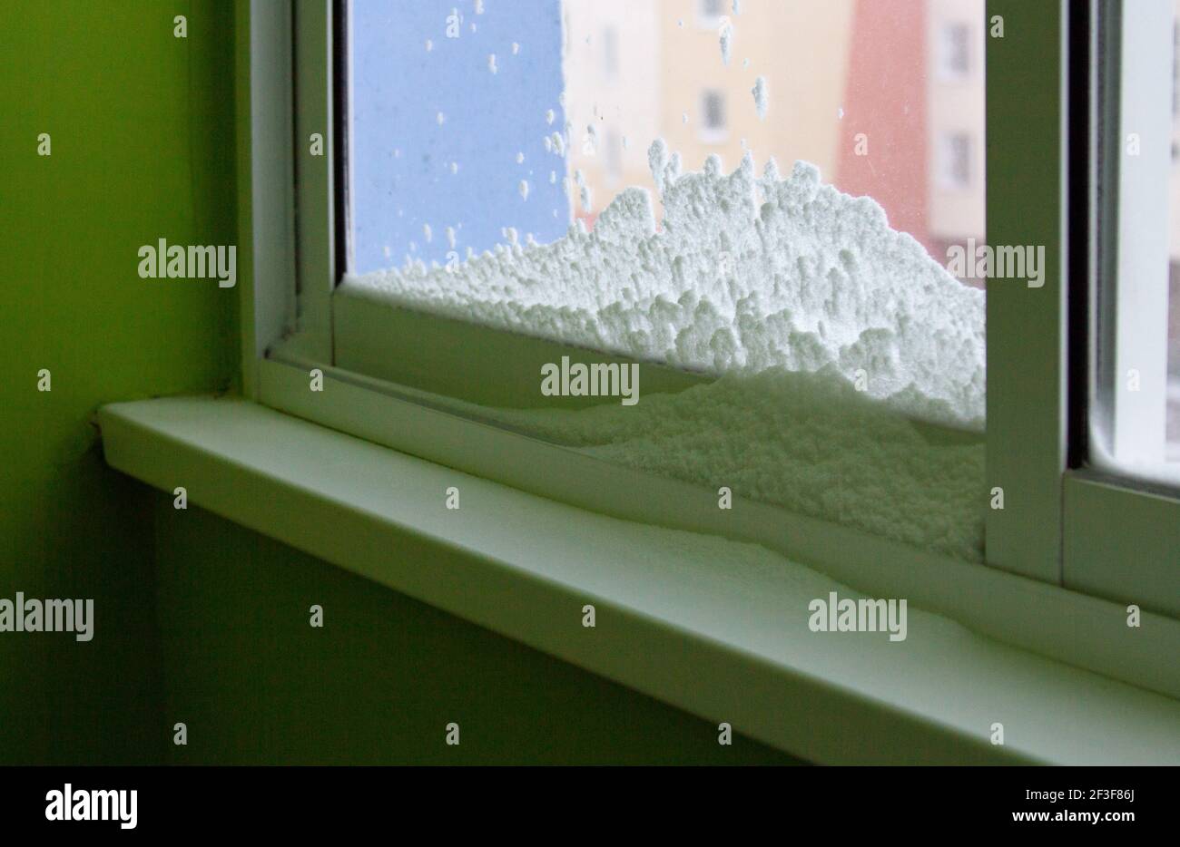 snow on the window glass, blizzard winter and frost outside the window ...