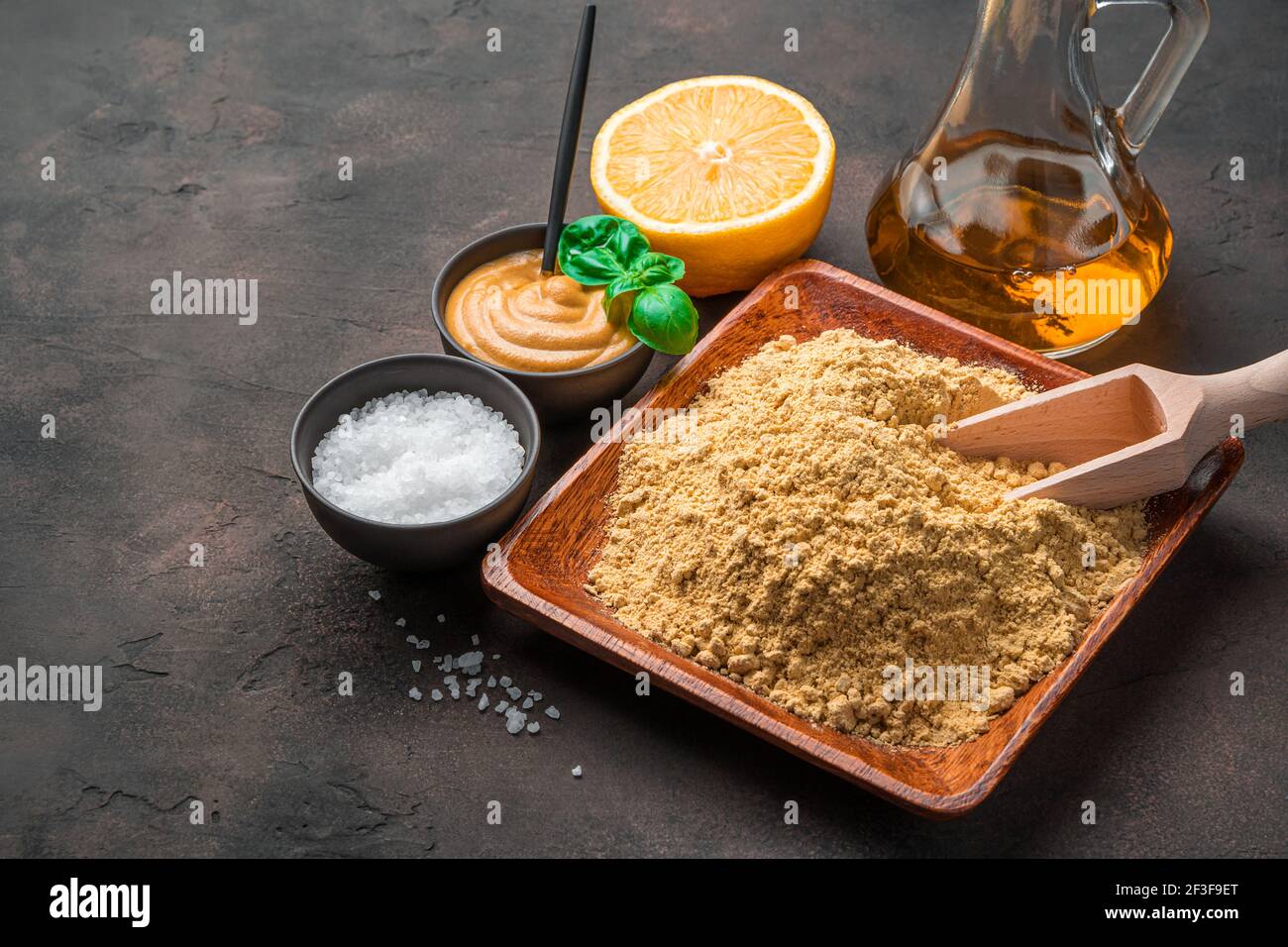 Mustard powder and ingredients on a brown background with space to copy ...