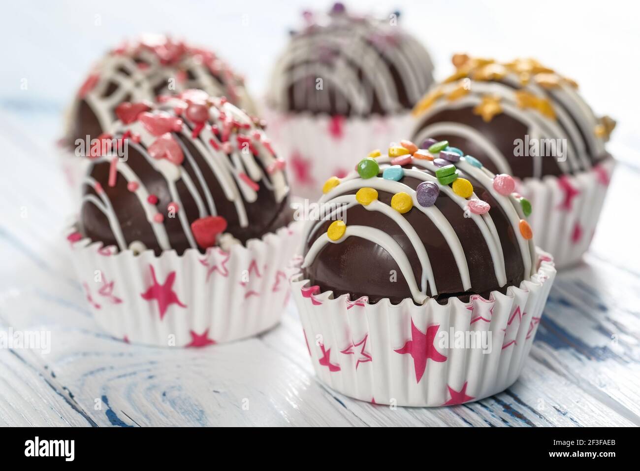 Cocoa bombs are black chocolate shells filled with cocoa powder and ...