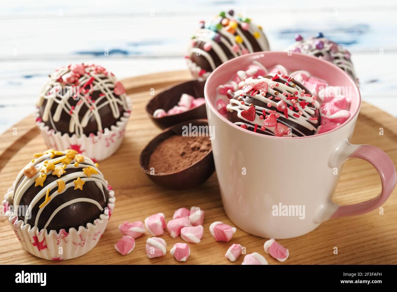 Cocoa bombs are black chocolate shells filled with cocoa powder and ...