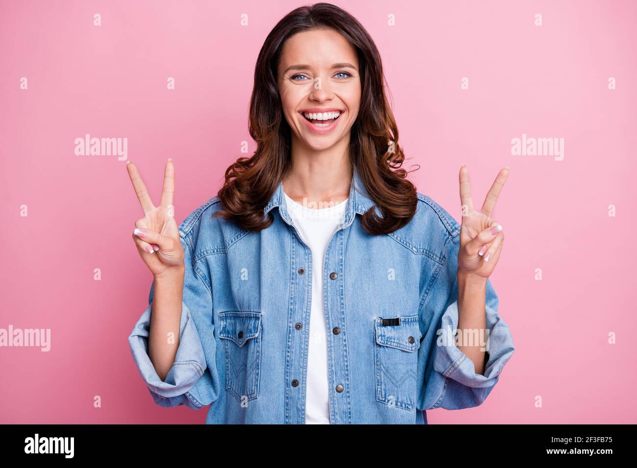Photo of positive happy pretty young woman hold two v-sign good mood ...