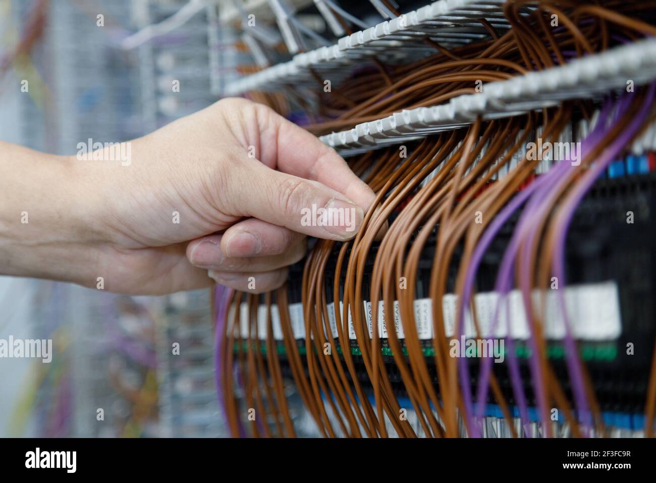 A hand touching the electrical wires in electrical terminal blocks ...