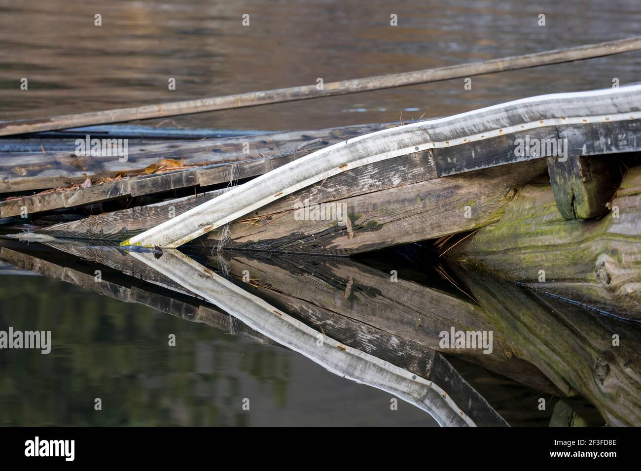 A mirror like reflection of an old broken down dock Stock Photo - Alamy