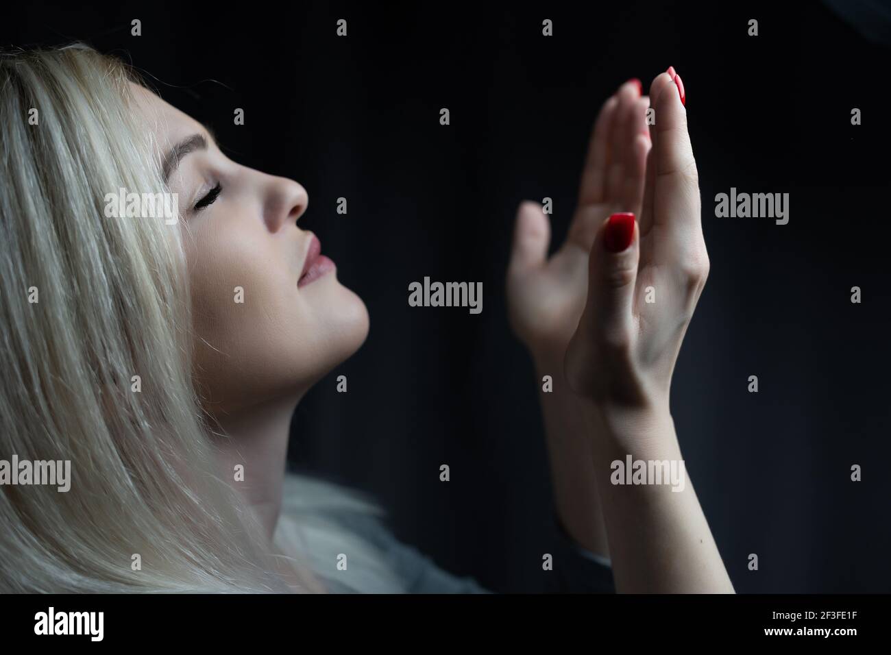 Closeup portrait of a young woman praying Stock Photo - Alamy