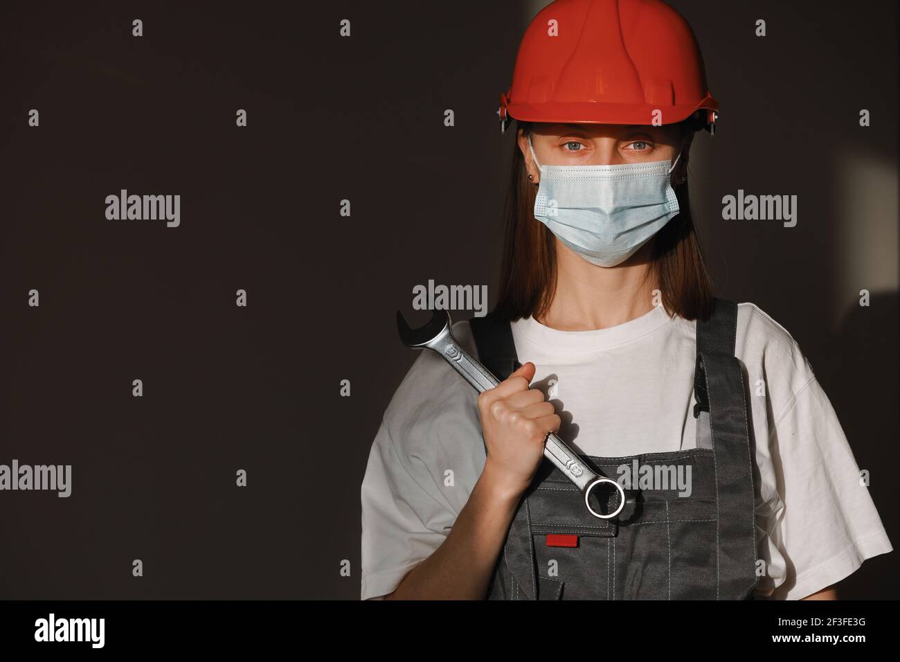portrait female worker is wear protection mask face, safety helmet and ...