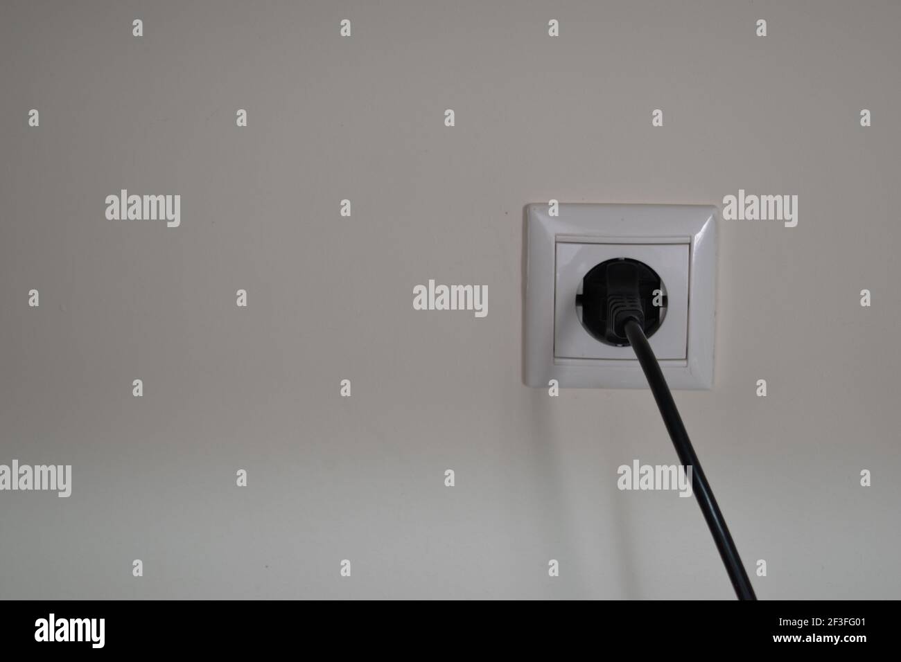 Electrical power socket and single plug black cable switched on ...