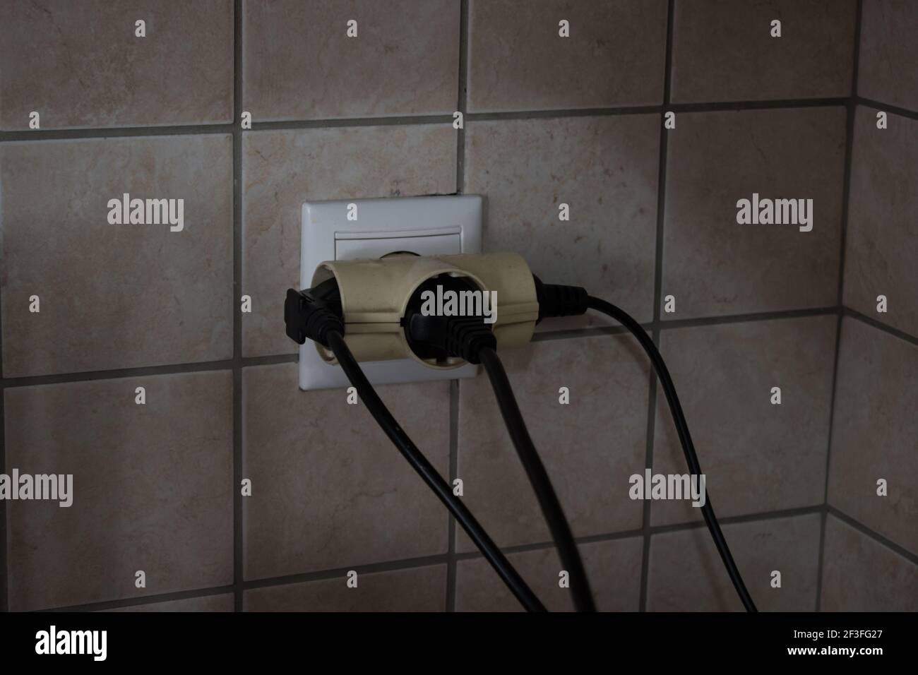 Overloaded outlet with an extension and many sockets plugged in, risk ...