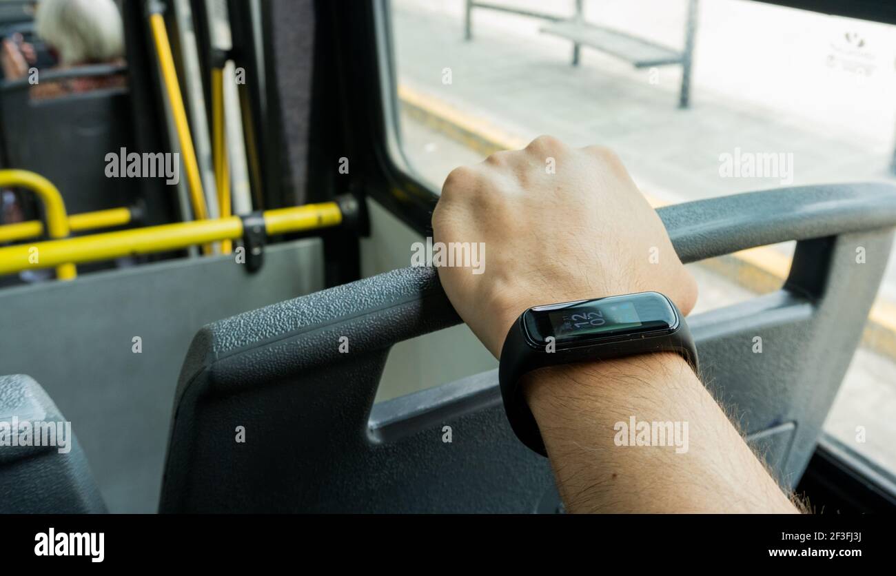 hand of a man with a smart watch holding a chair on a public bus ...