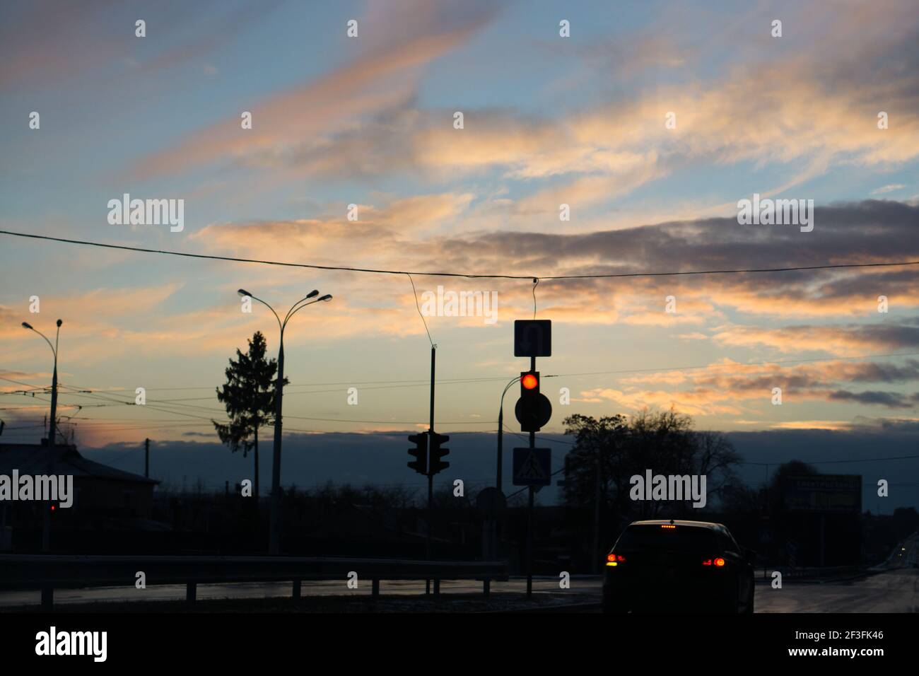 silhouette of car stop at crossroads on red traffic light at sunset ...