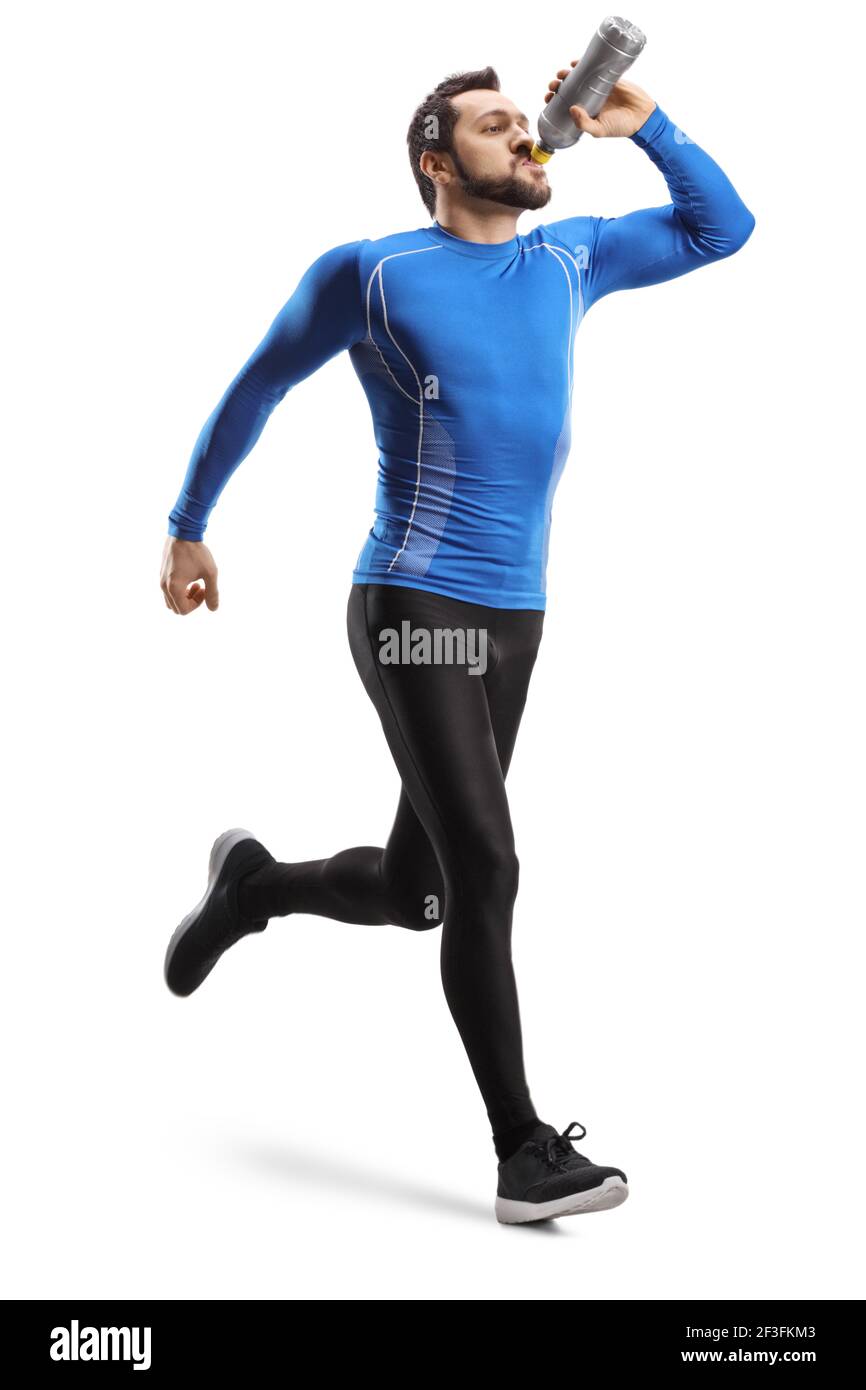 Full length shot of a fit man running and drinking from a bottle ...