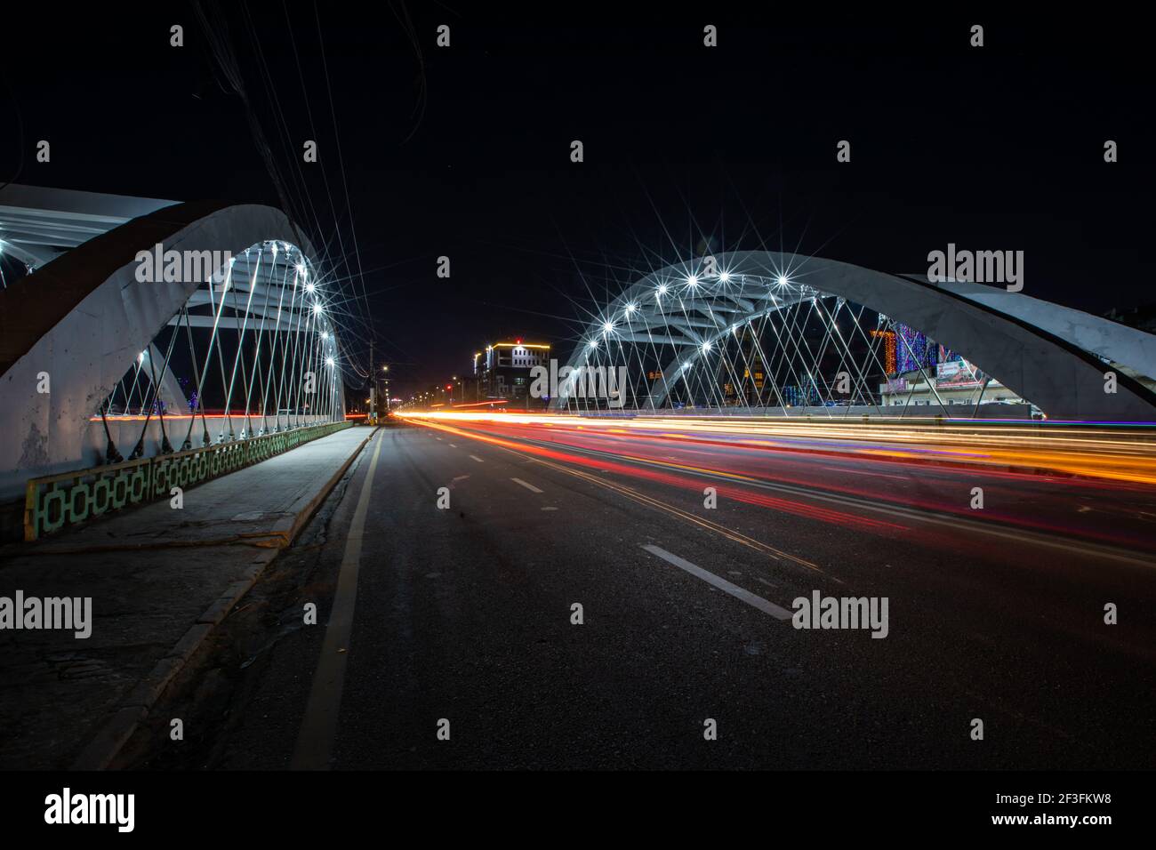 an expressway on the steel arch bridge at night with white lights Stock ...