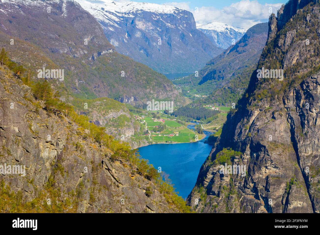 View on Norwegian fjord village in the distance, looking through rocks ...