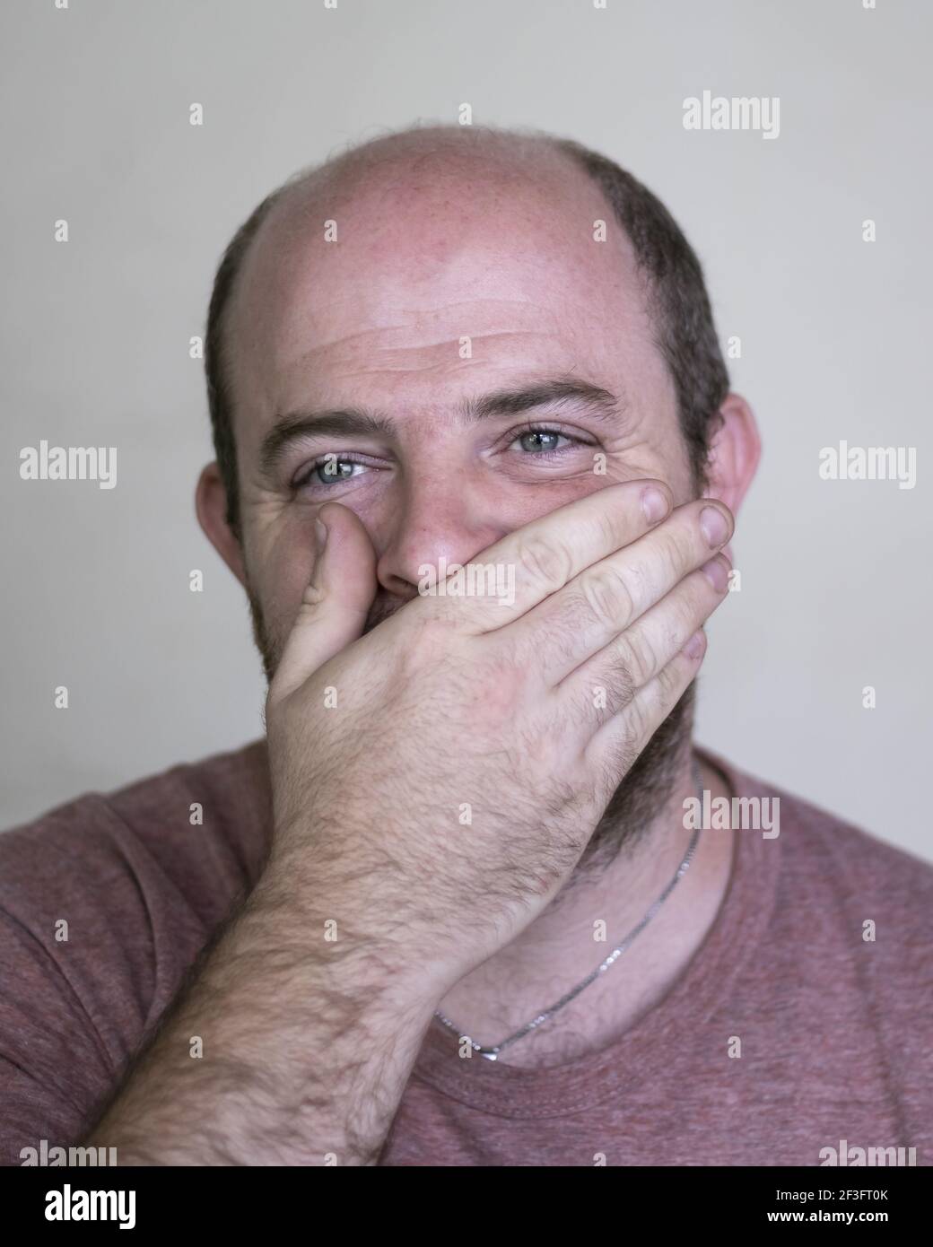 A vertical shot of a male making a shocked face on a white background ...