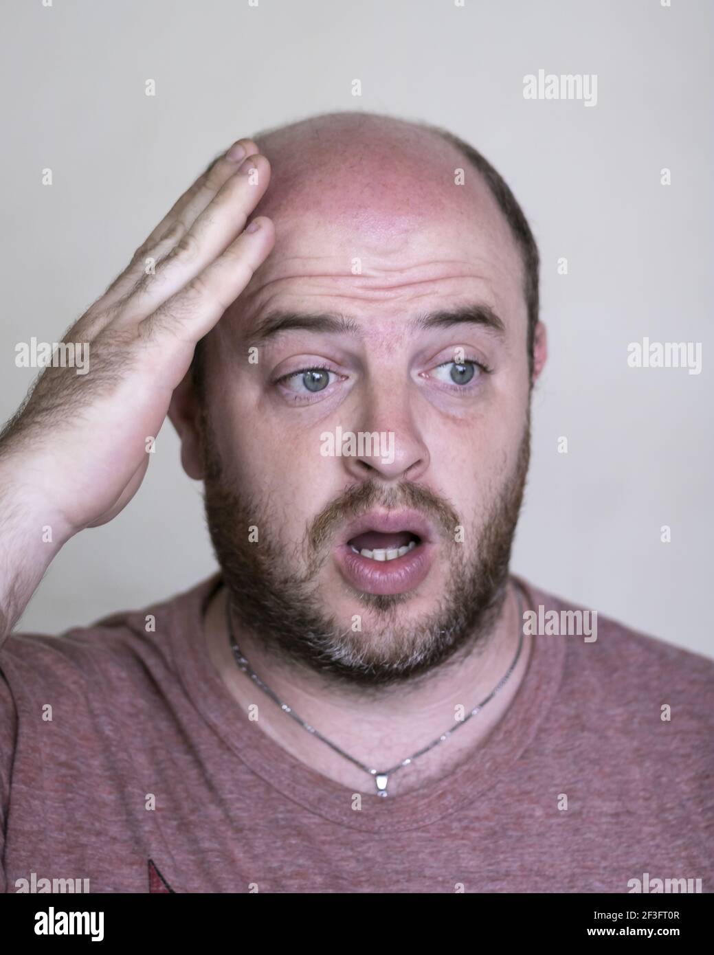 A vertical shot of a male making a shocked face on a white background ...