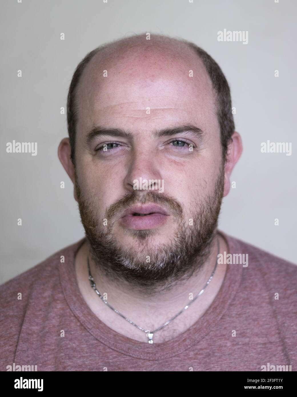 A vertical shot of a male with a shocked face on a white background ...