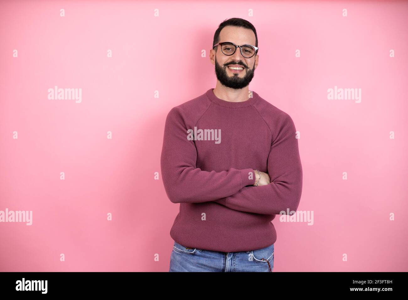 Handsome man wearing glasses and casual clothes over pink background ...