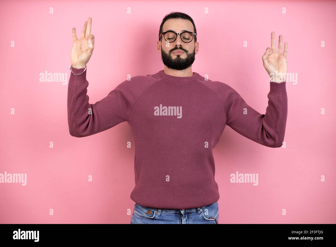 Handsome man wearing glasses and casual clothes over pink background ...