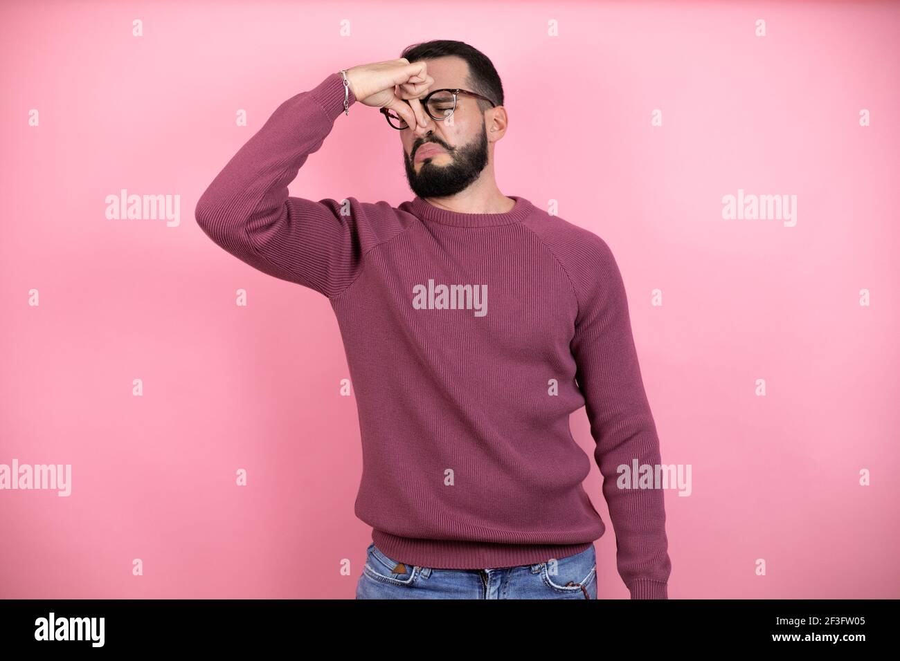 Handsome man wearing glasses and casual clothes over pink background ...