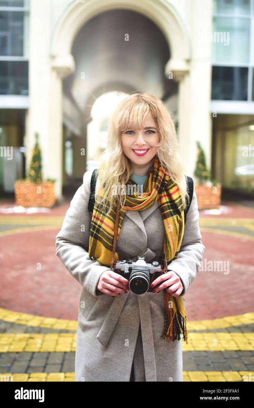 Blonde pretty photographer woman with retro camera in her hands while ...