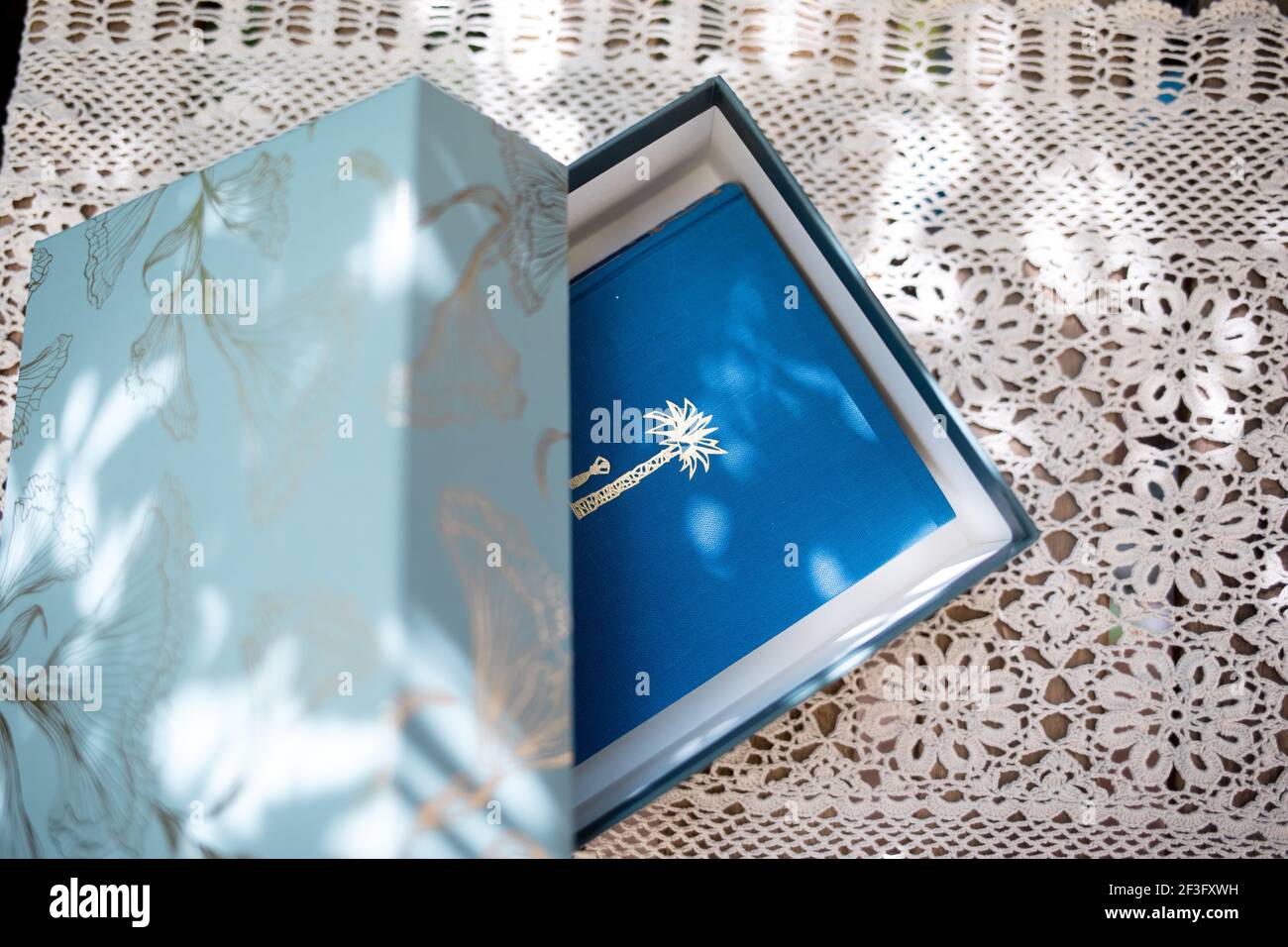 A closeup shot of a notebook in blue gift box on white tablecloth Stock ...