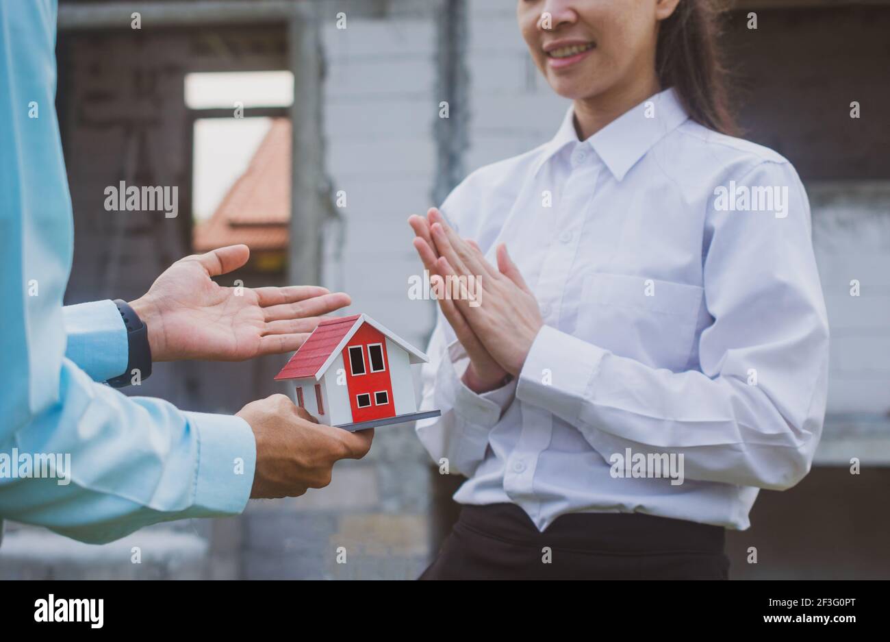Salesman giving house to customer Stock Photo - Alamy