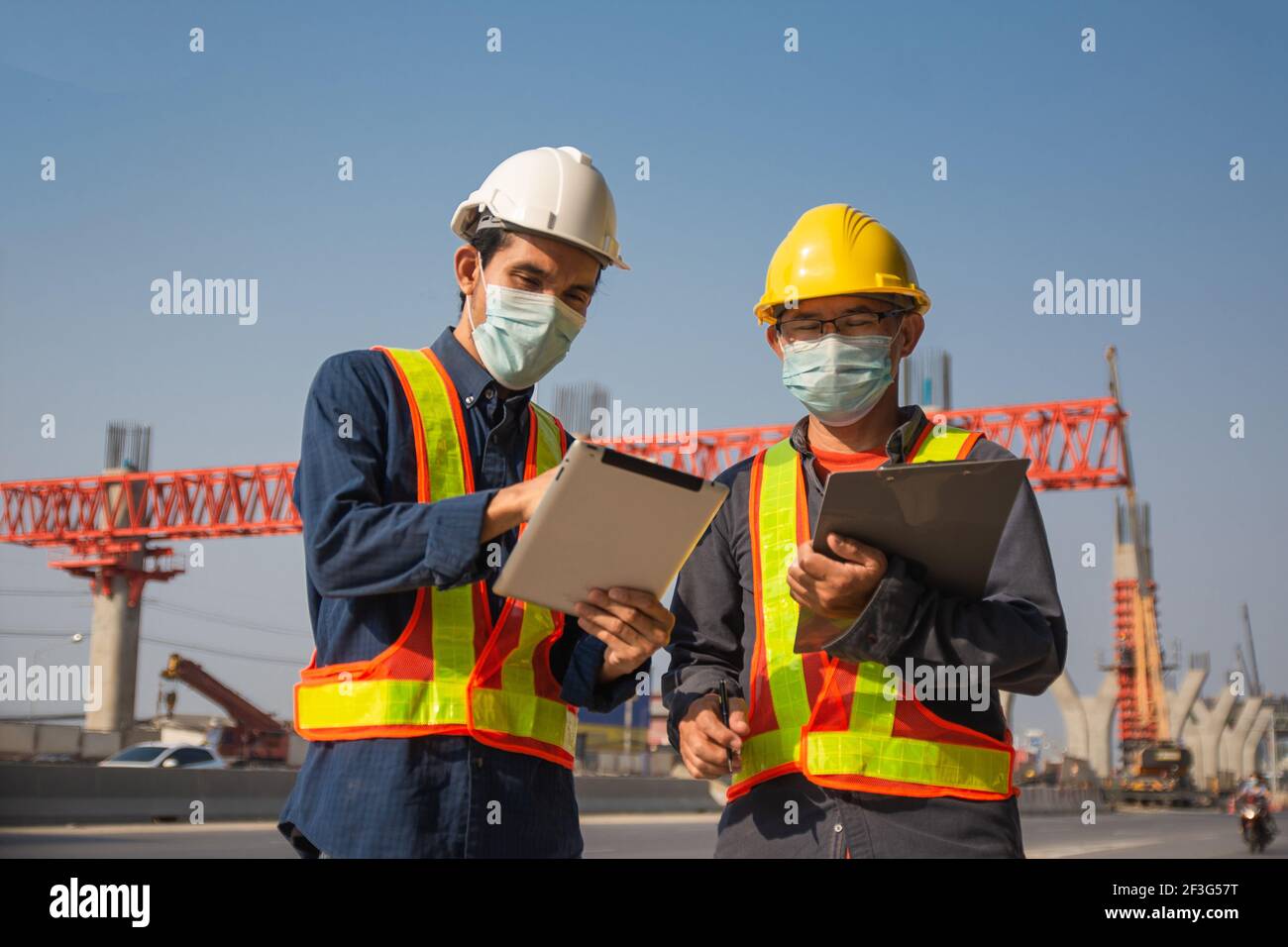 Two Engineer worker tablet working on site road construction, Asian man ...