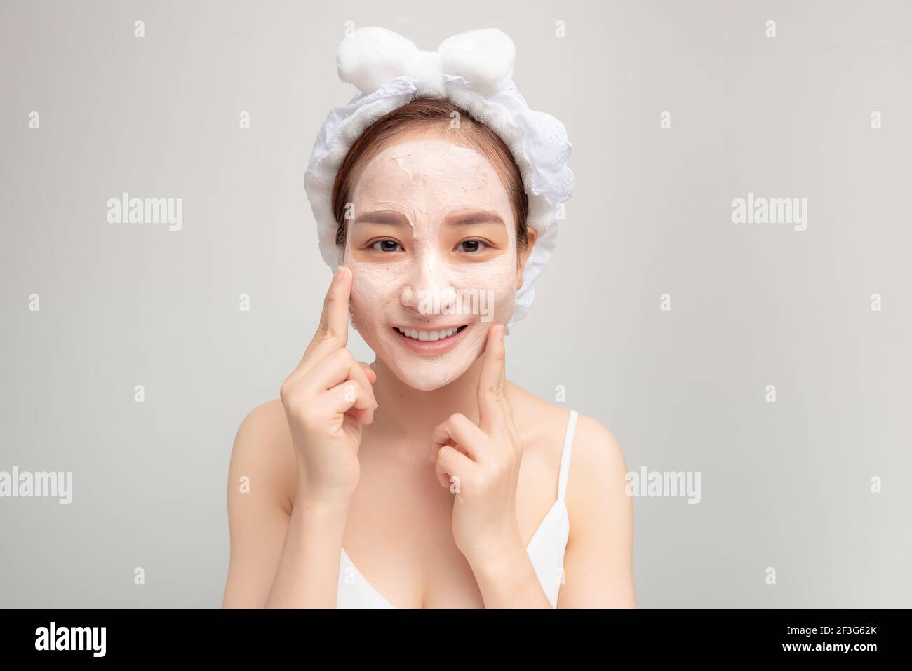 Spa dreams. A portrait of a beautiful relaxing lady with a clay mask on ...